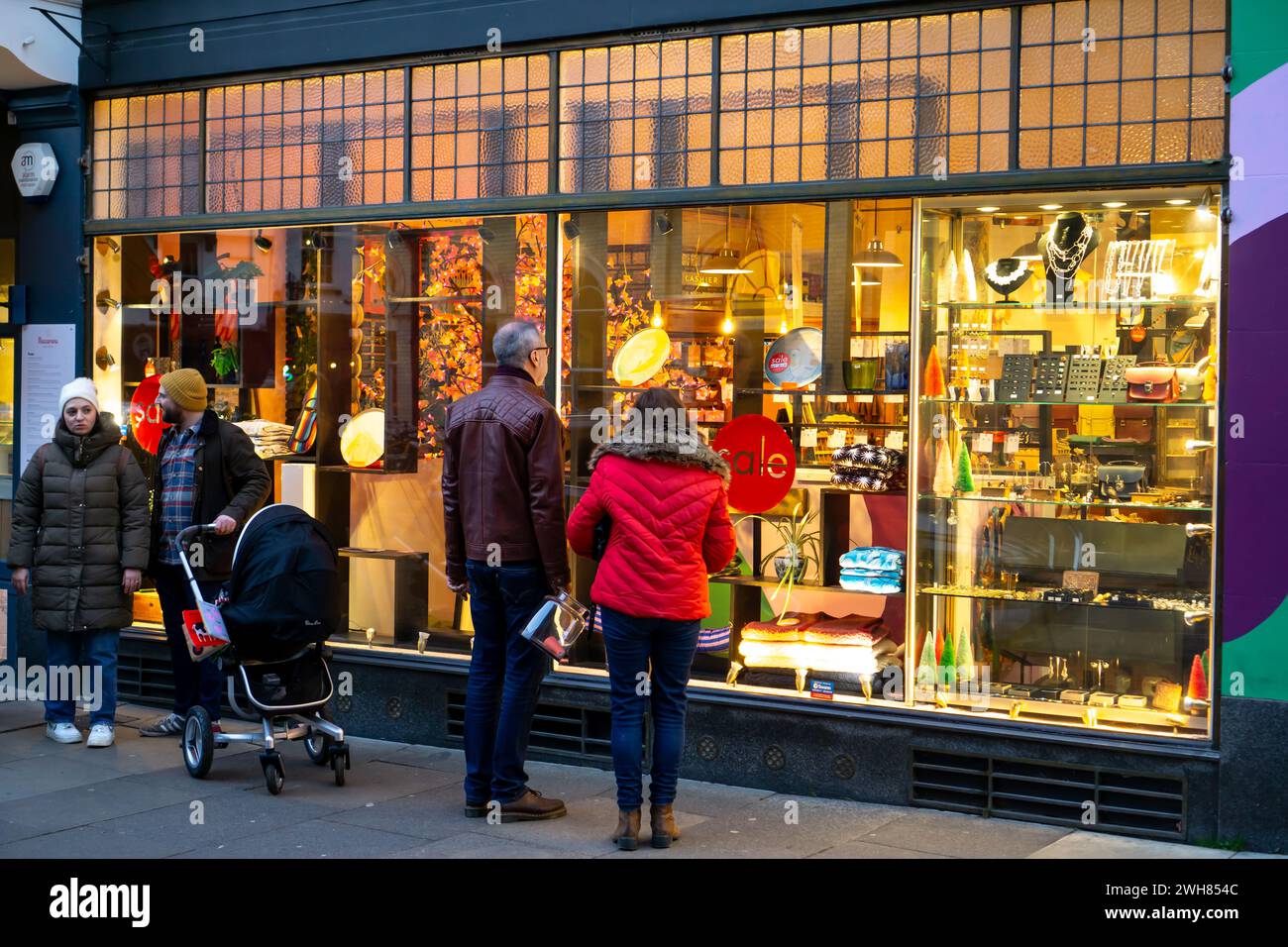 People window shopping outside a illuminated shop window Stock Photo ...