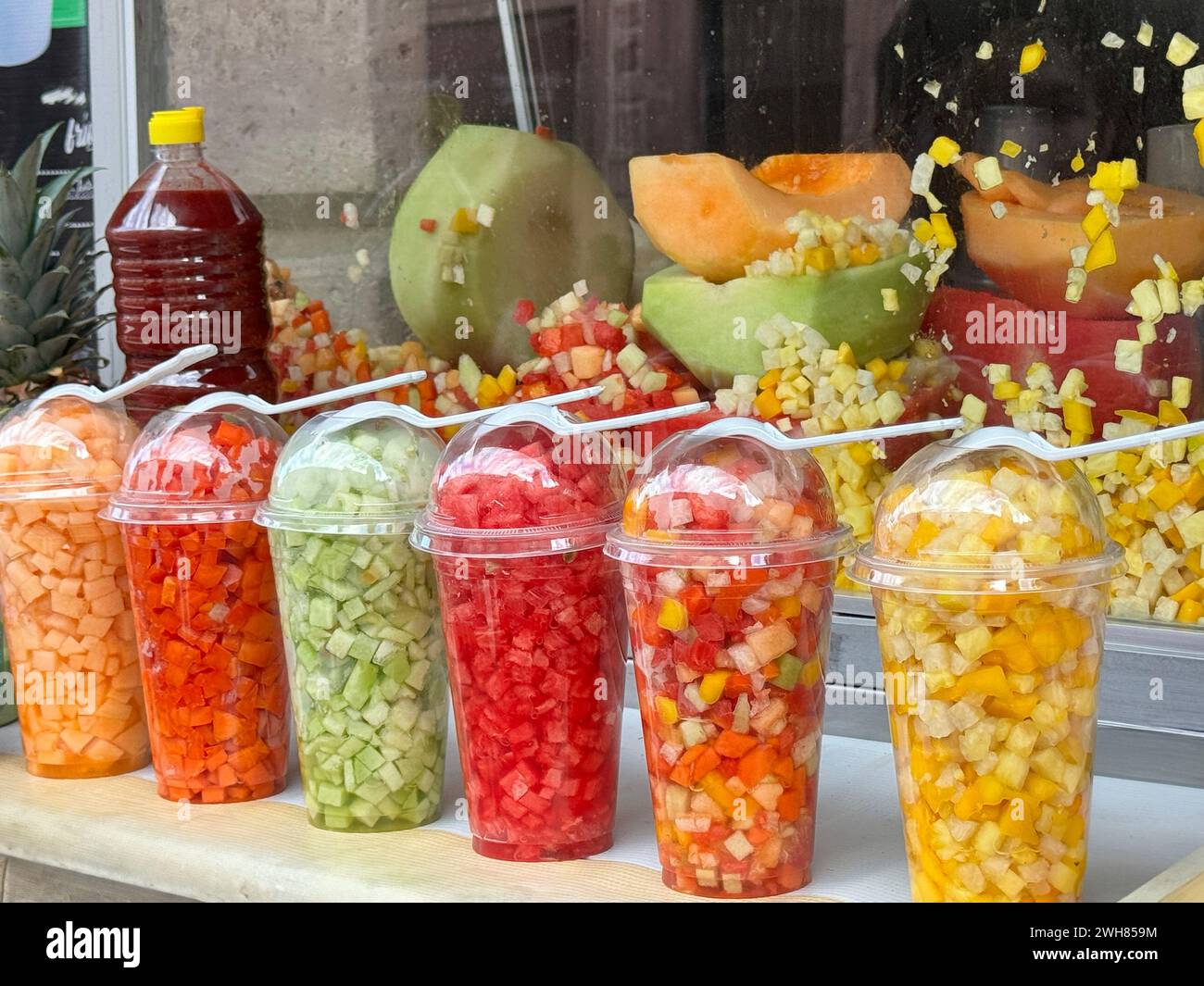 A colorful array of freshly diced fruit cups for sale, featuring papaya ...