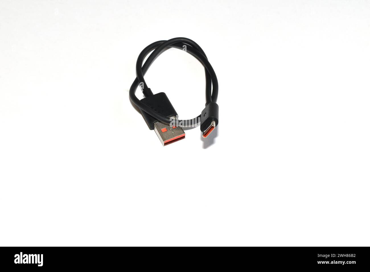 A twisted black USB cable lies on a white background Stock Photo - Alamy