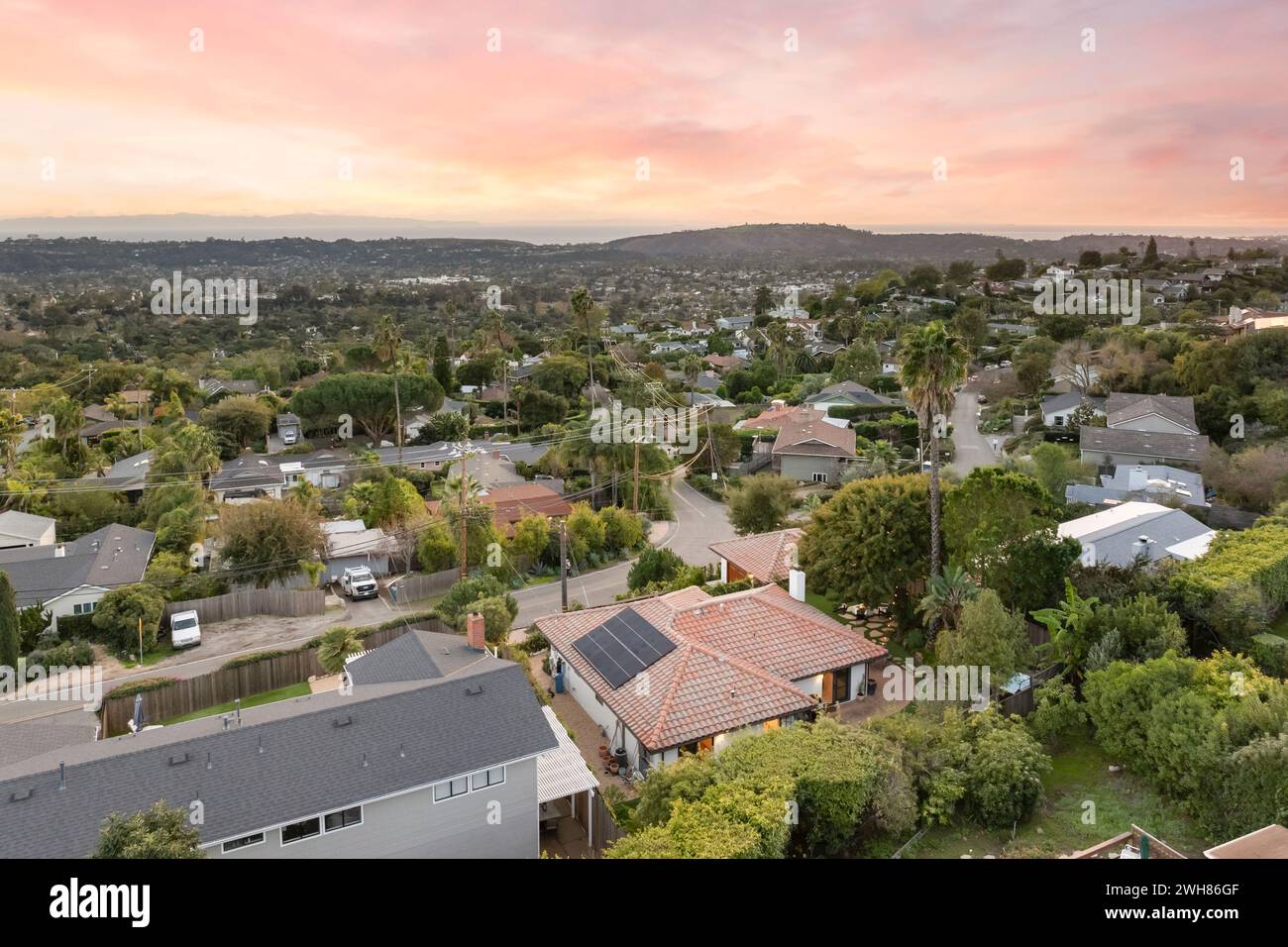 Aerial view of suburban sunset revealing buildings and tree Stock Photo ...