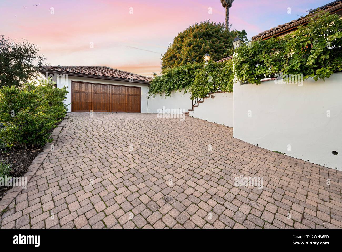Brick paver driveway leading to a garage Stock Photo - Alamy