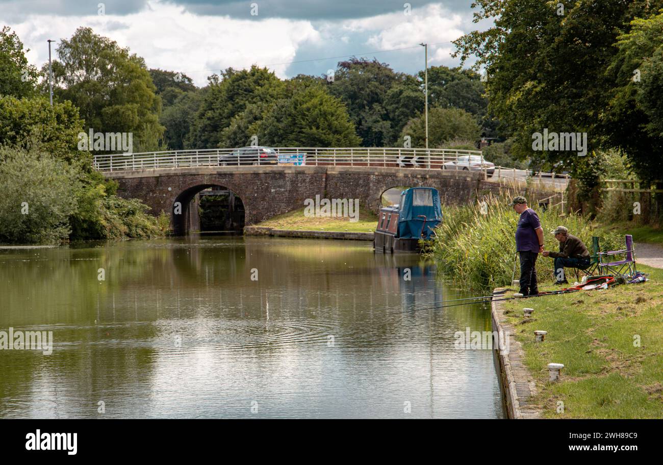 Two men fishing on the Kennet and Avon canal Devizes Wiltshire UK one ...