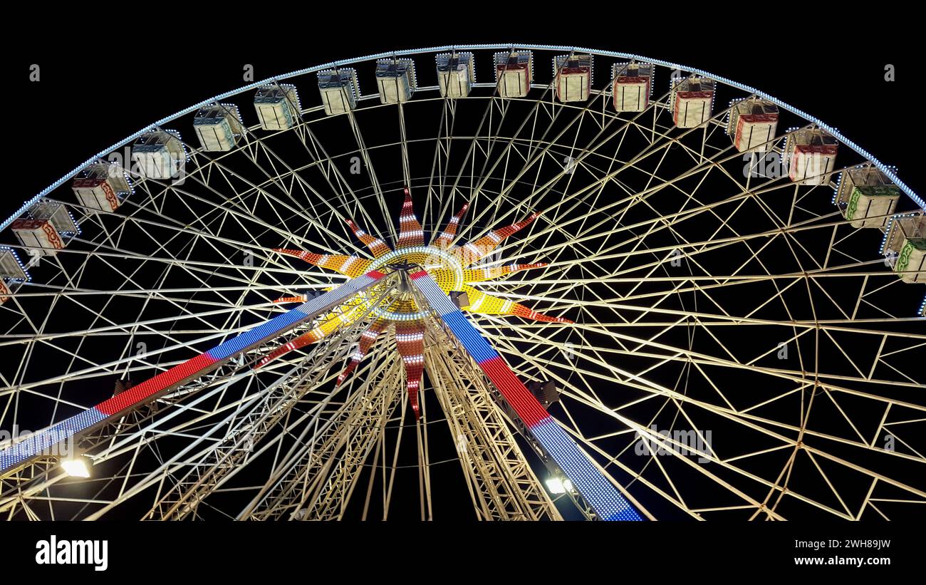 Nighttime view of a stunning ferris wheel against a dark backdrop Stock ...