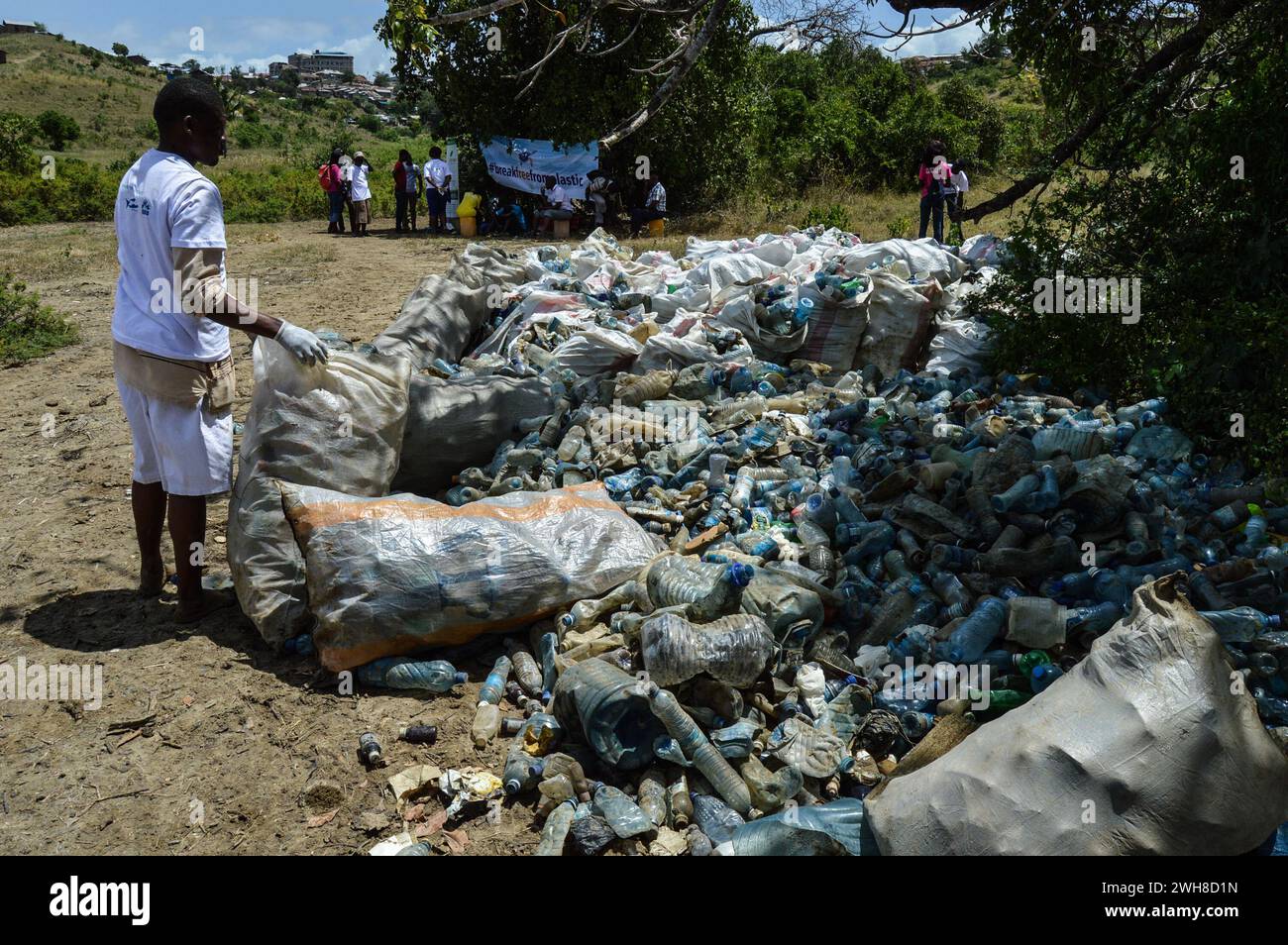 Mombasa, Kenya. 11th Sep, 2018. A volunteer stands beside a heap of ...