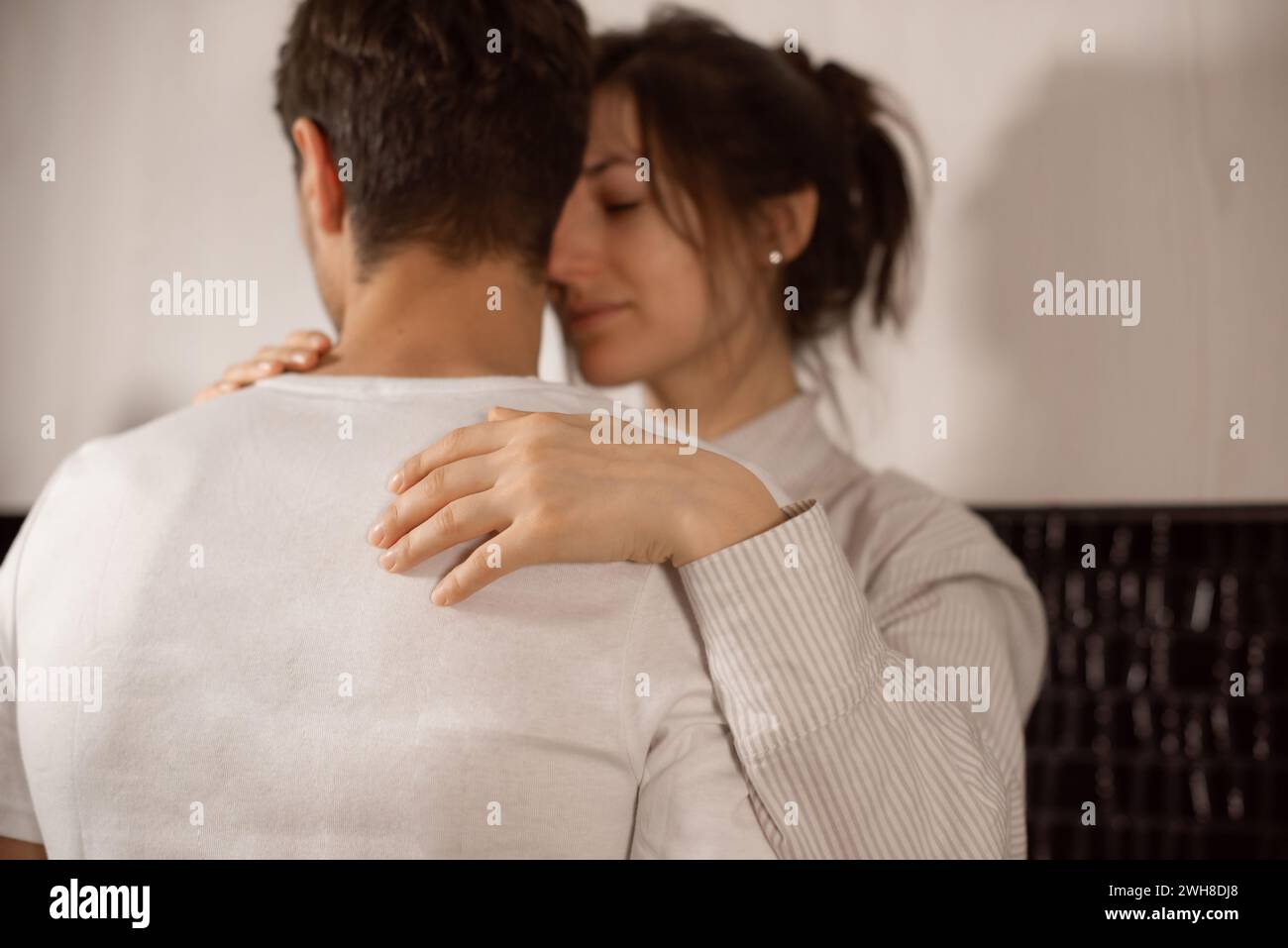 woman trustingly hugs her lover's neck. female feels protected behind his strong back Stock ...