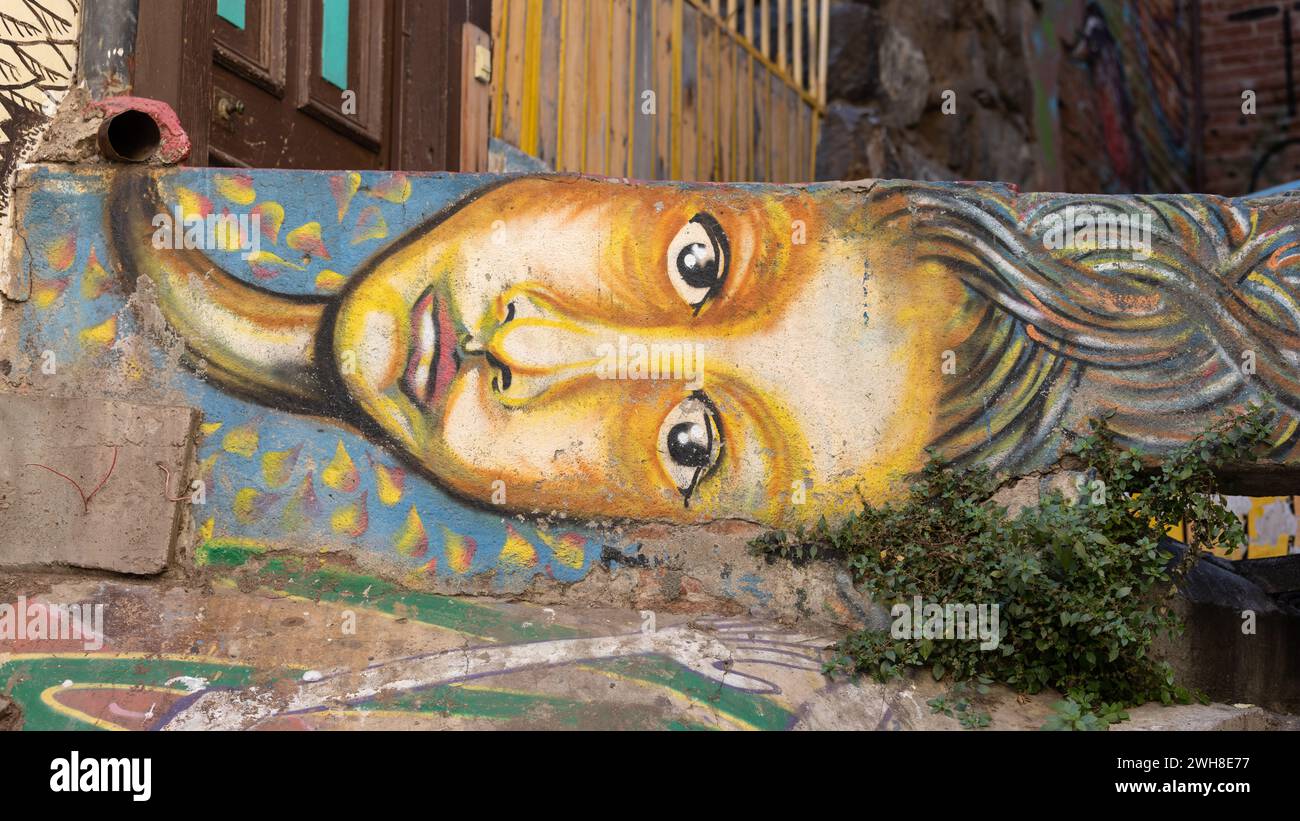 Street art, an oversized image of a woman on a crumbling wall in the ...