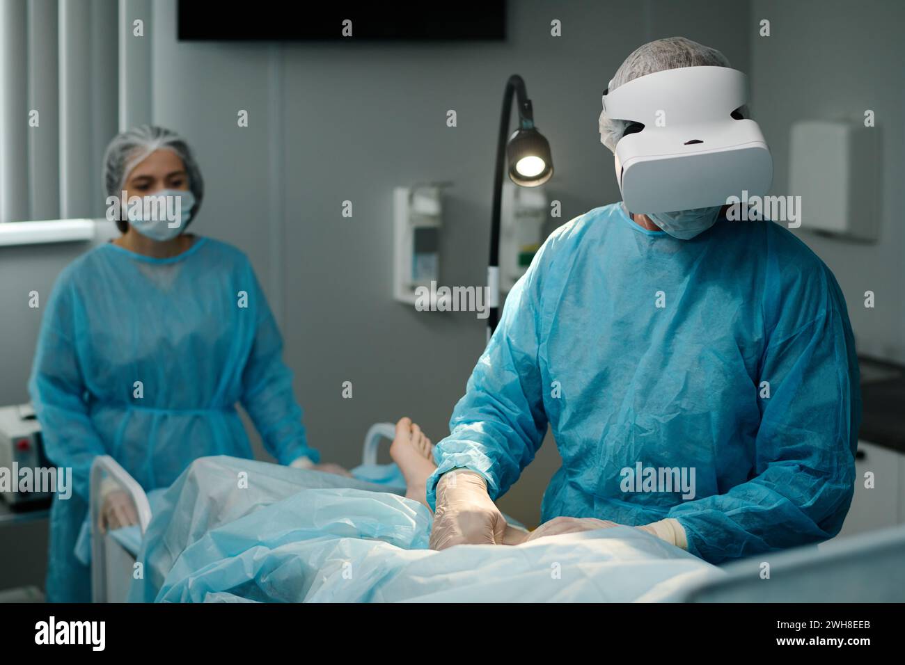 Experienced surgeon in VR headset performing surgical operation on leg ...
