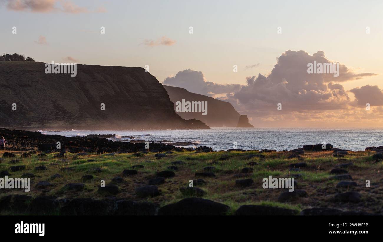 Evening sun bathes the beautiful Pacific coast of Easter Island around ...