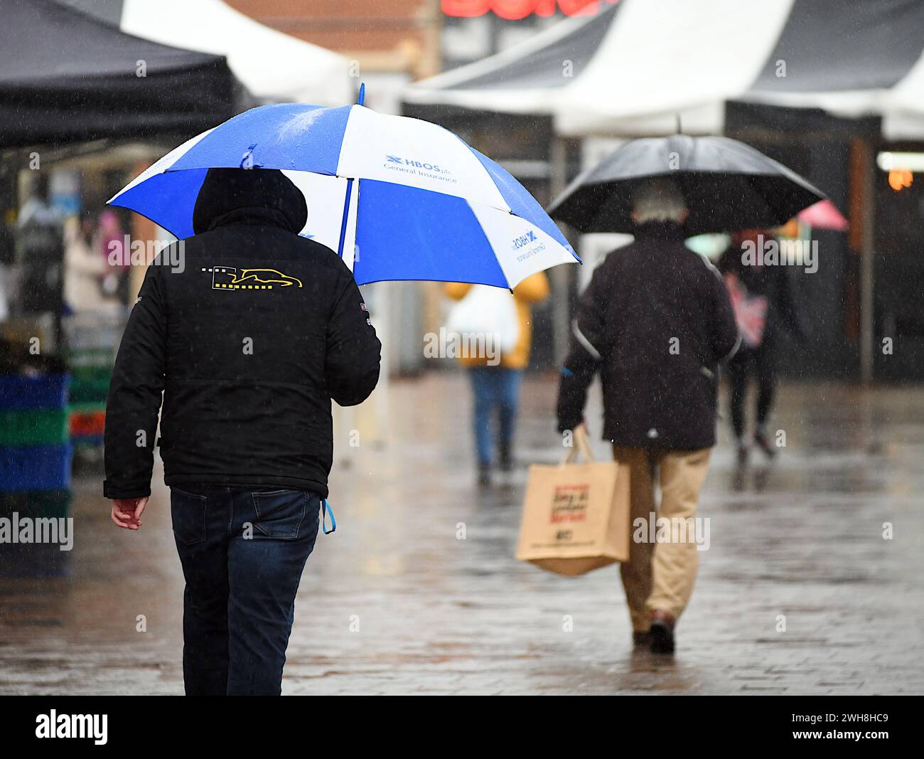 People keeping dry with umbrellas in the pouring rain in Loughborough ...