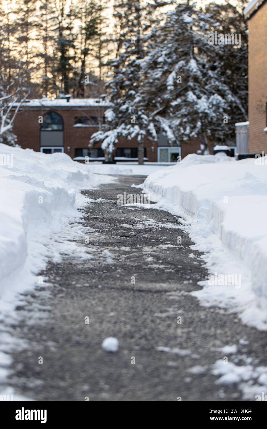 Winter road cleared of snow. Salt used to melt snow near houses Stock ...