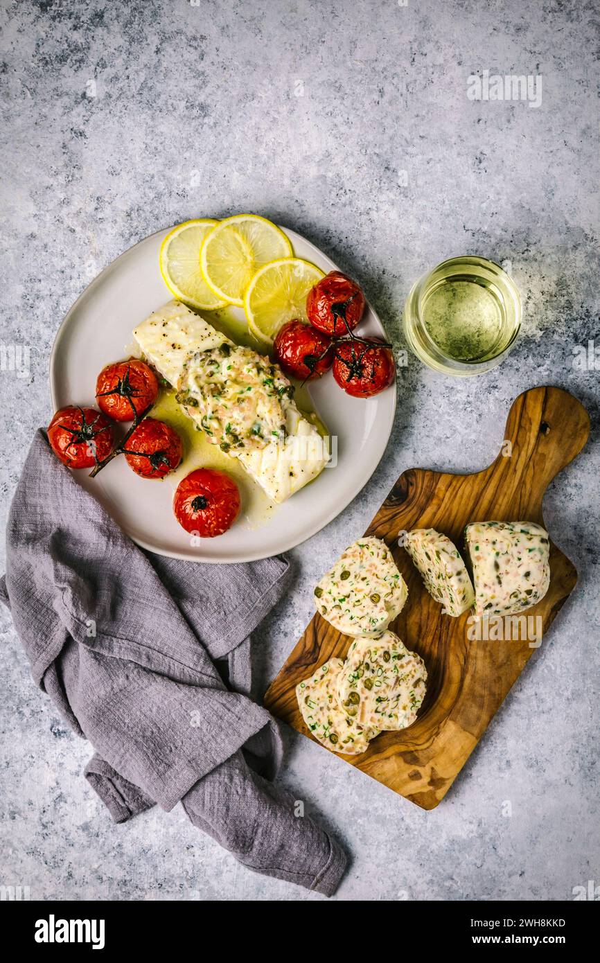 Overhead shot with White fish filet topped with melting compound butter ...