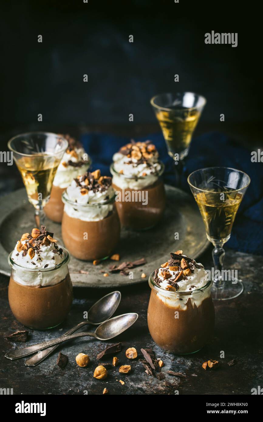 Individual jars of chocolate mousse, topped with whipped cream ...