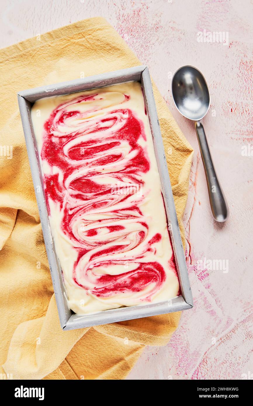 Raspberry Ripple Ice Cream Tub on Pink Background with Yellow Napkin ...
