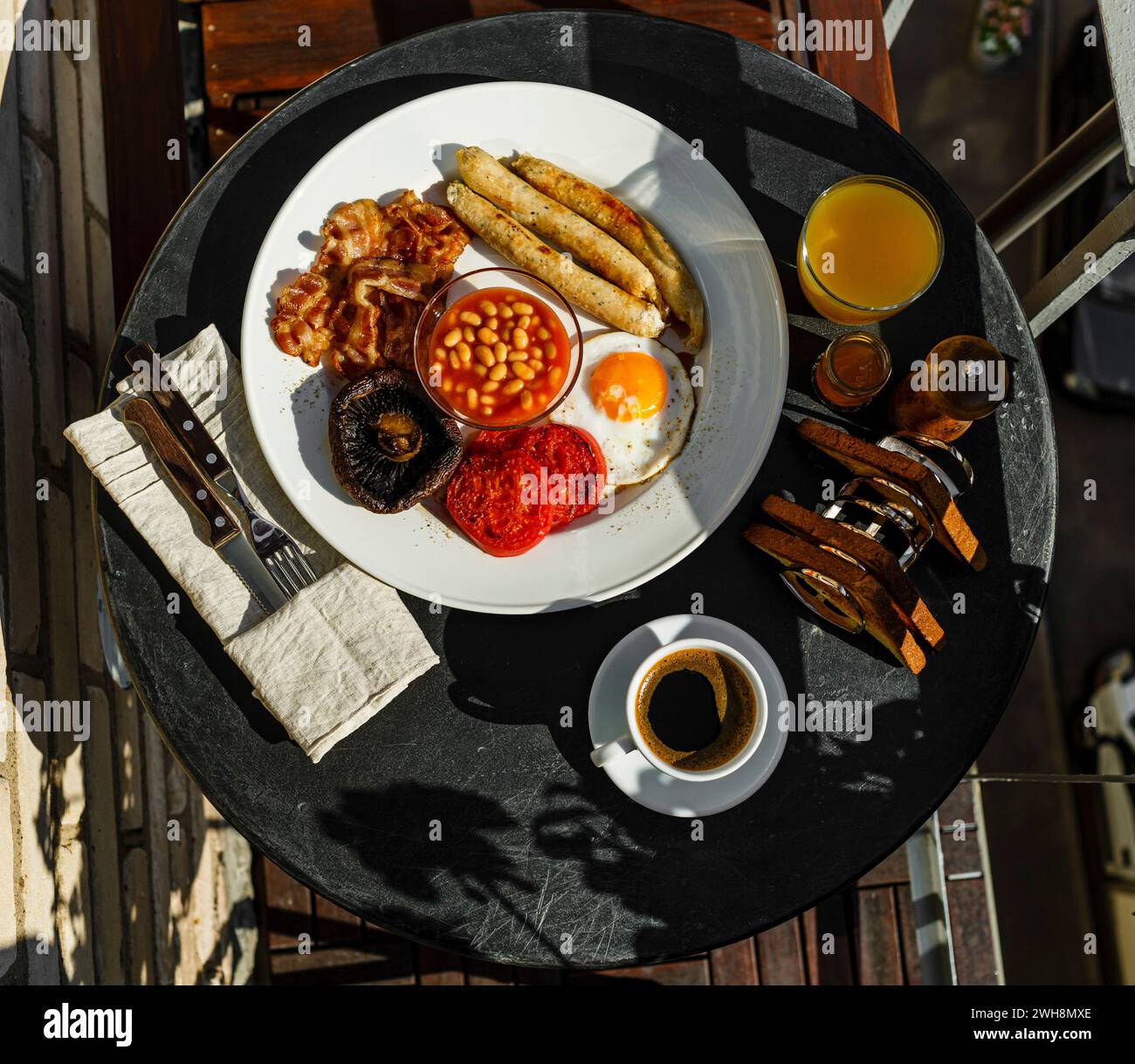 Full fry up English breakfast with fried eggs, sausages, bacon, beans ...