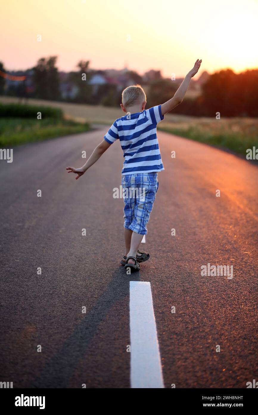 Cute baby boy running on the road at sunset Stock Photo - Alamy