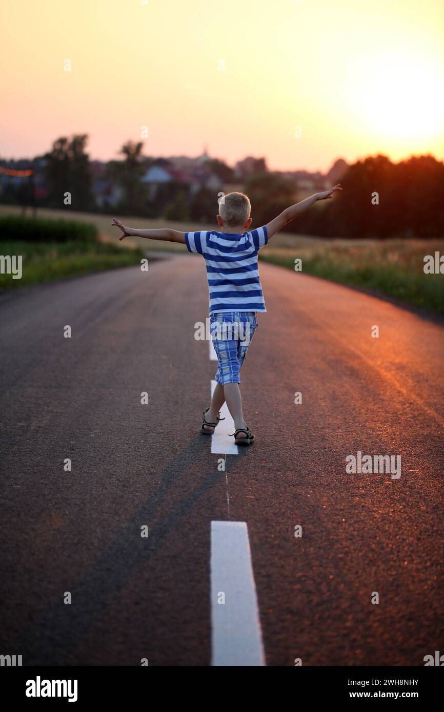 Cute baby boy running on the road at sunset Stock Photo - Alamy