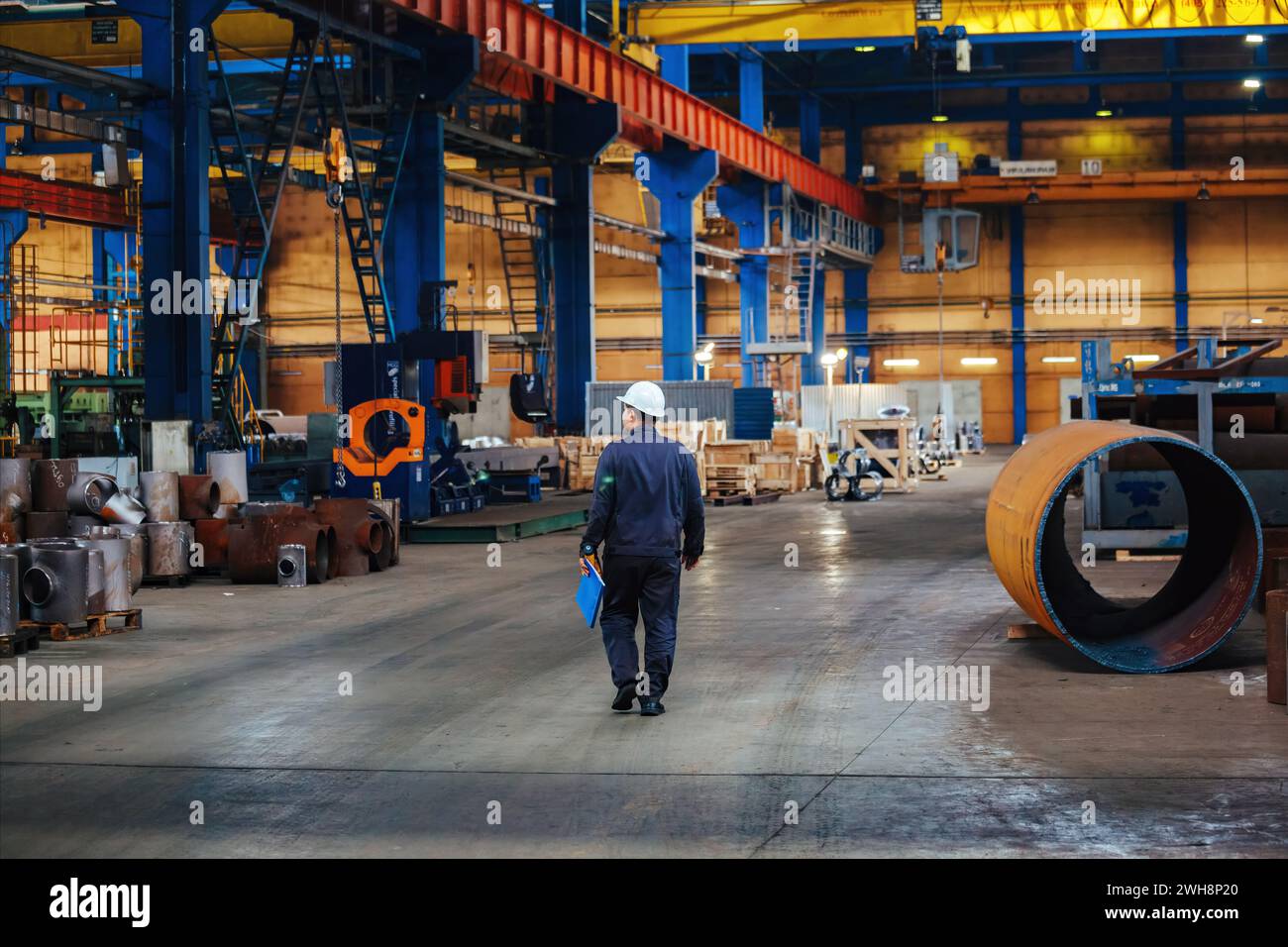 Industrial worker walking at pipe factory Stock Photo - Alamy