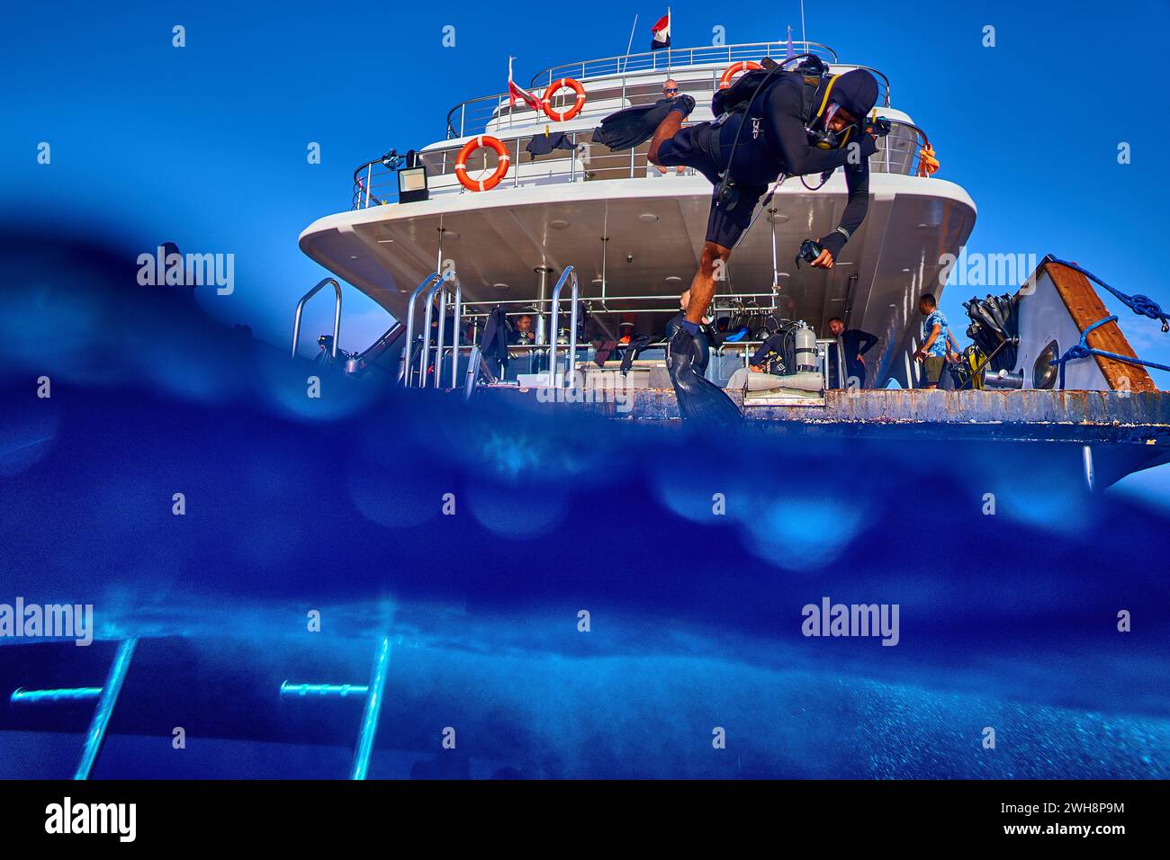 The beauty of the underwater world - diver jumping from boat into water ...