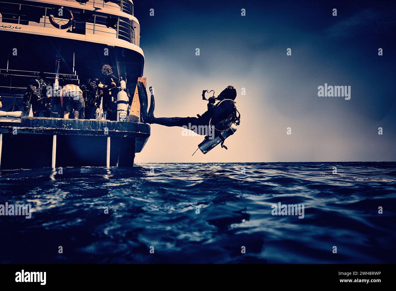 The beauty of the underwater world - diver jumping from boat into water ...