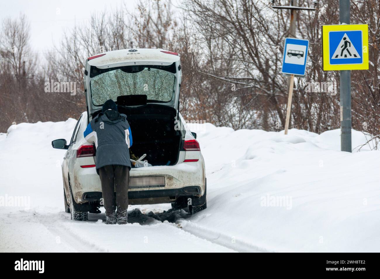 Consequences of snowfall The driver opened the trunk of a car parked on ...