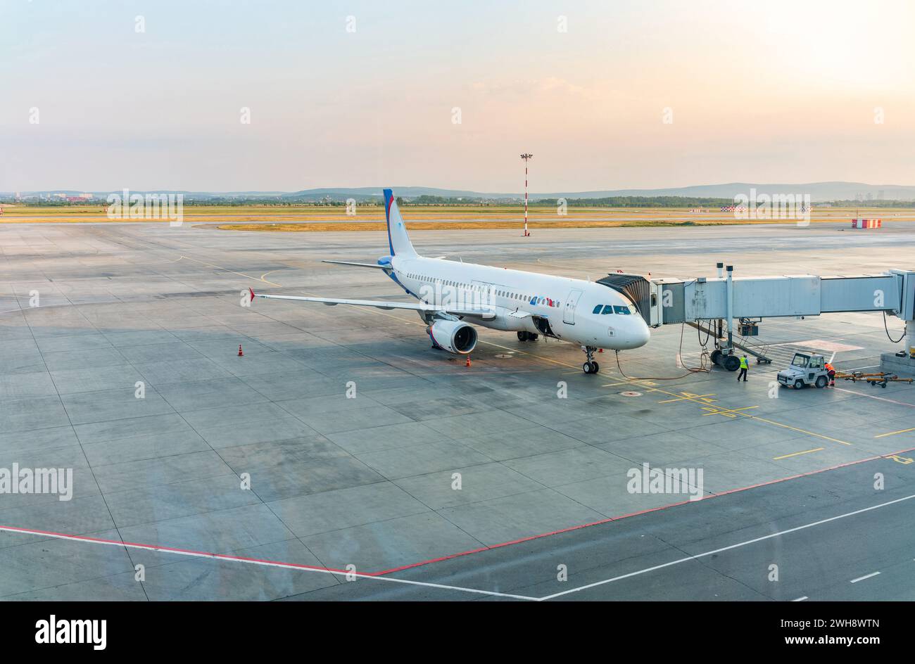 Passenger plane on the airfield connected to walkway.The gate sleeve is ...