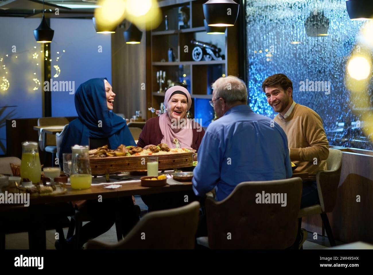 A modern and traditional European Islamic family comes together for iftar in a contemporary ...
