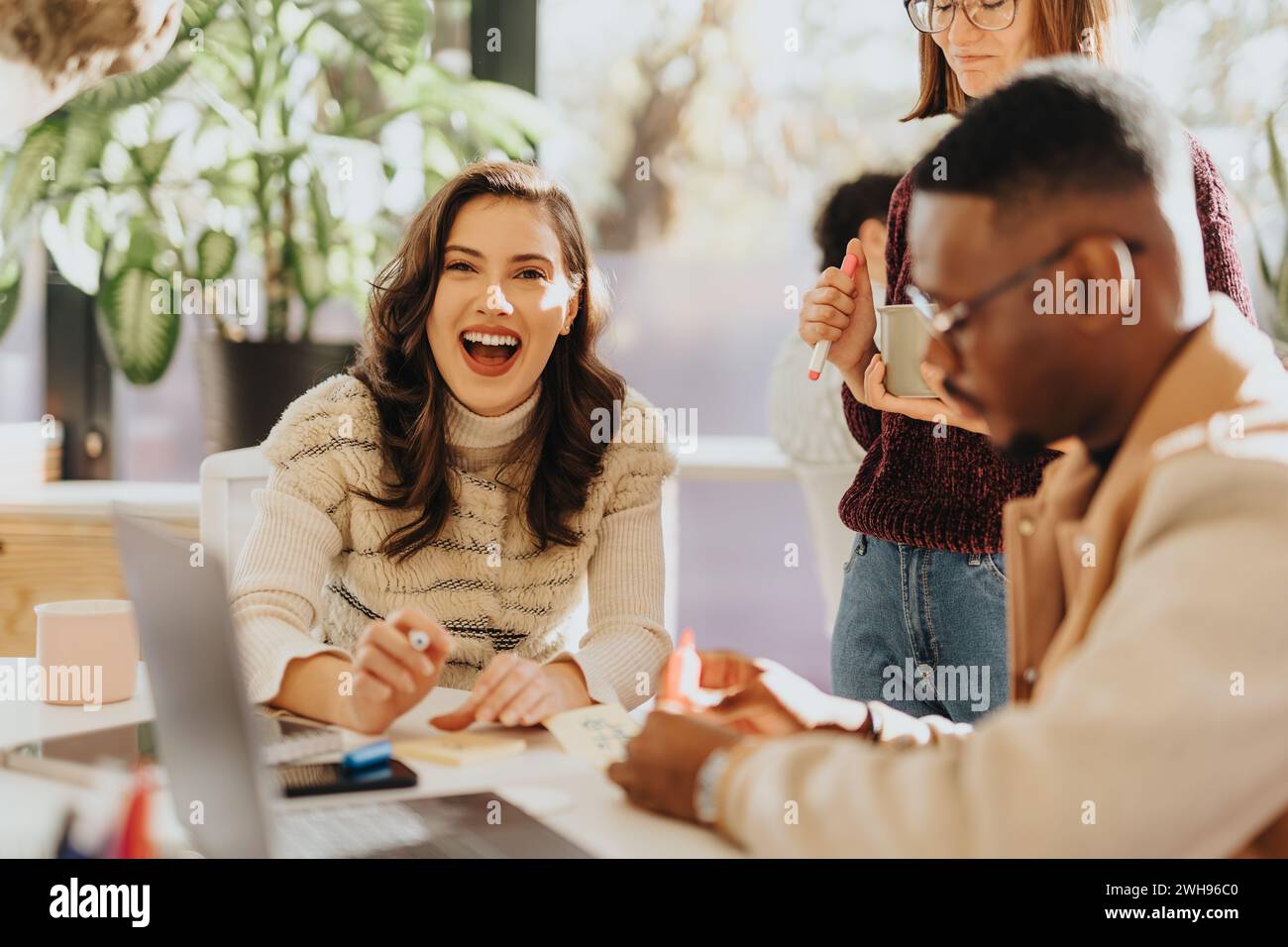 Collaborative business meeting in a modern sunlit workplace. People ...