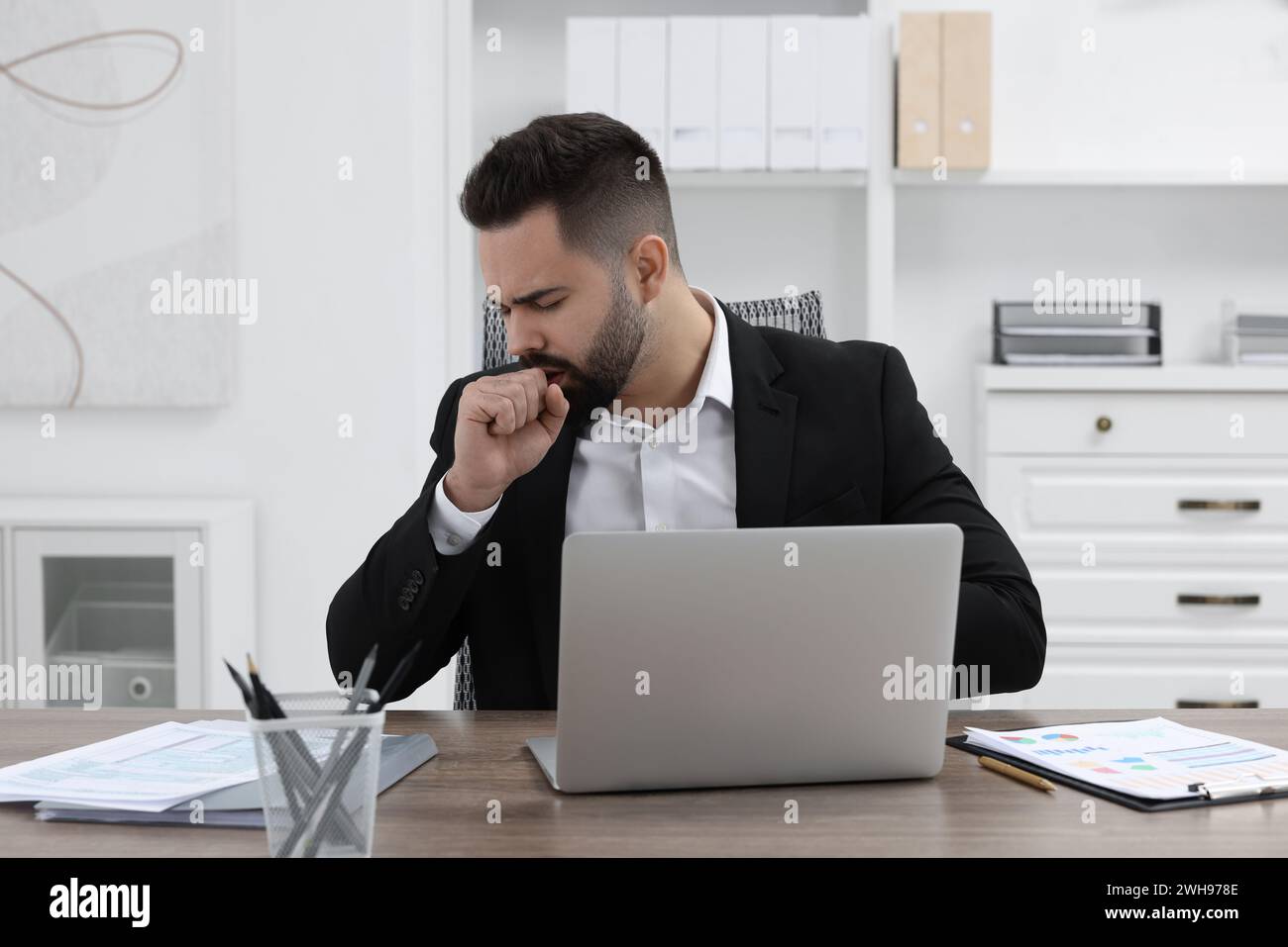 Sick man coughing at workplace in office Stock Photo - Alamy