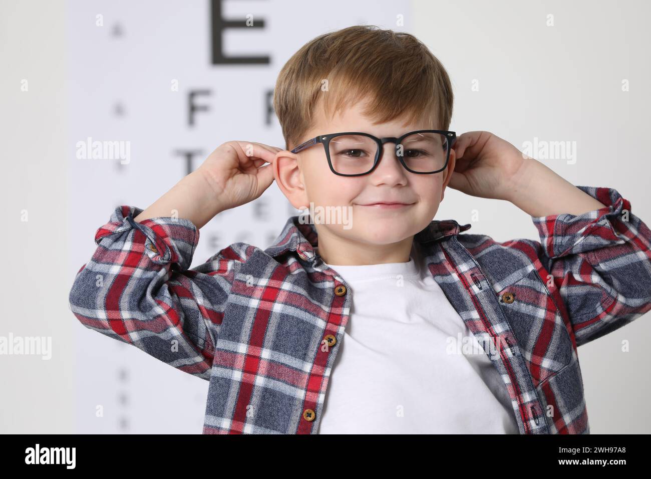 Little boy with glasses against vision test chart Stock Photo - Alamy