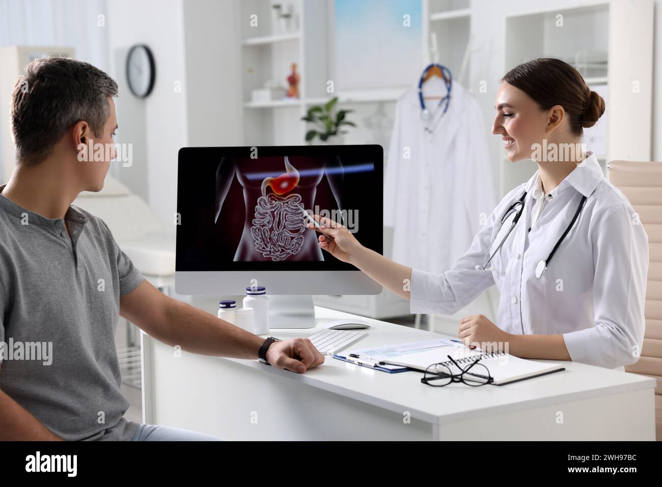 Gastroenterologist showing screen with illustration of digestive tract ...