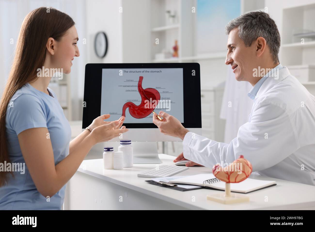 Gastroenterologist showing screen with illustration of human stomach ...