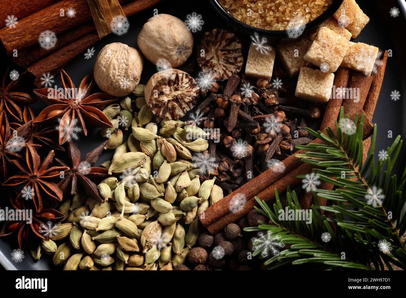 Different spices and fir tree branches on black background, flat lay ...