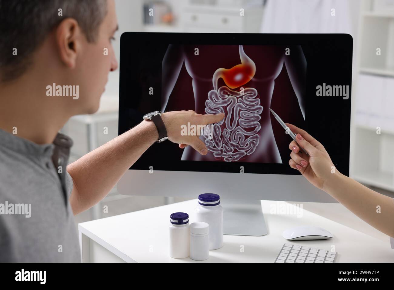 Gastroenterologist showing screen with illustration of digestive tract ...
