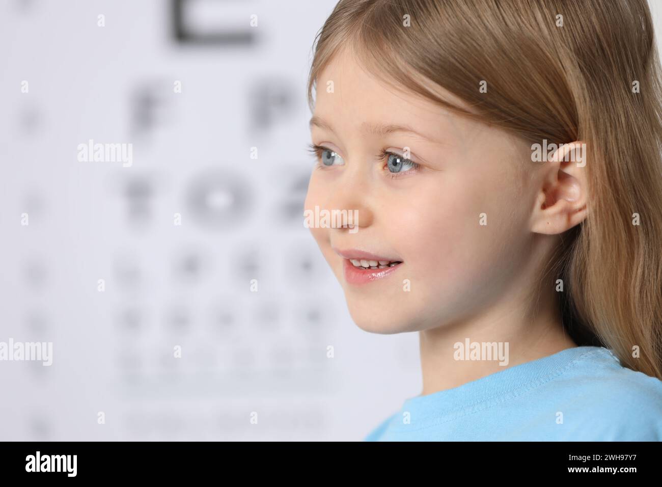 Cute little girl against vision test chart, closeup Stock Photo - Alamy