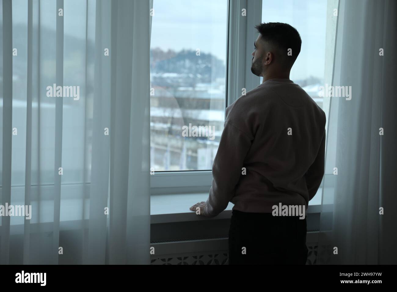 Sad man looking at window at home, back view. Space for text Stock ...