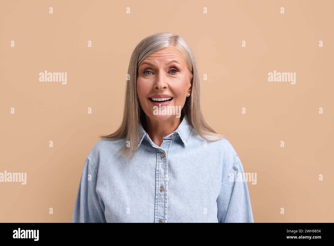 Portrait of emotional middle aged woman on beige background Stock Photo - Alamy