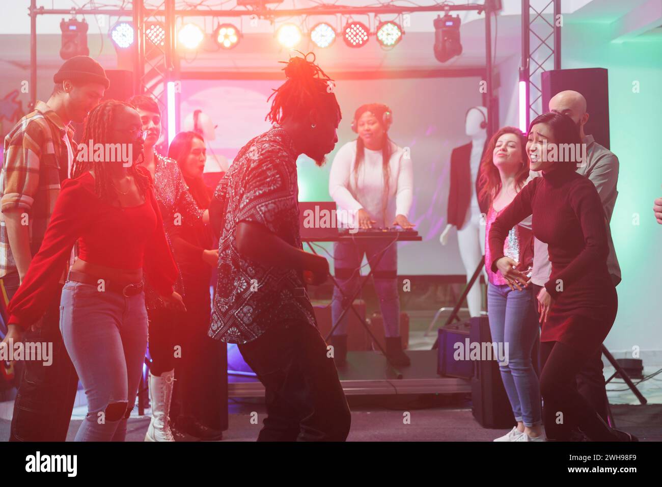 Young man and woman showing moves at dance battle while partying in ...