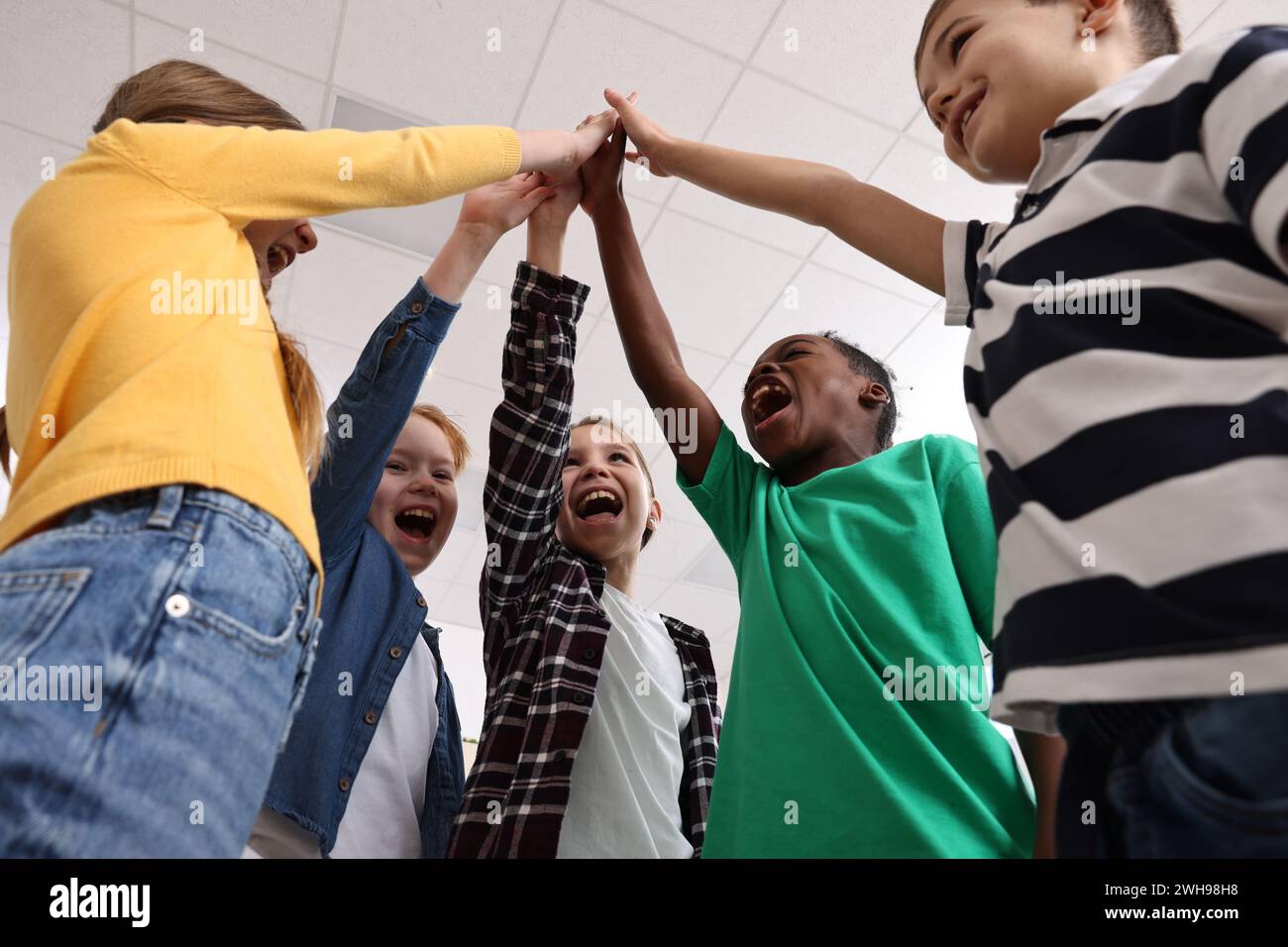Happy children giving high five at school, low angle view Stock Photo ...