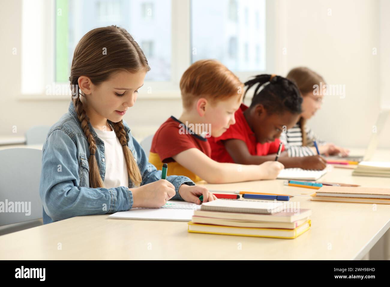 Cute children studying in classroom at school Stock Photo - Alamy