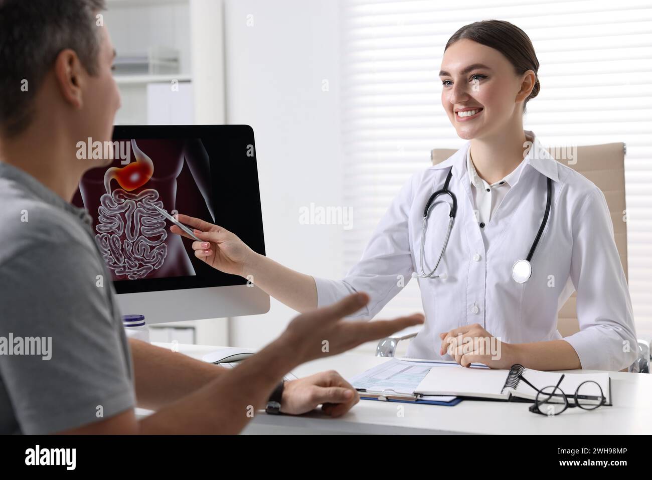 Gastroenterologist showing screen with illustration of digestive tract ...