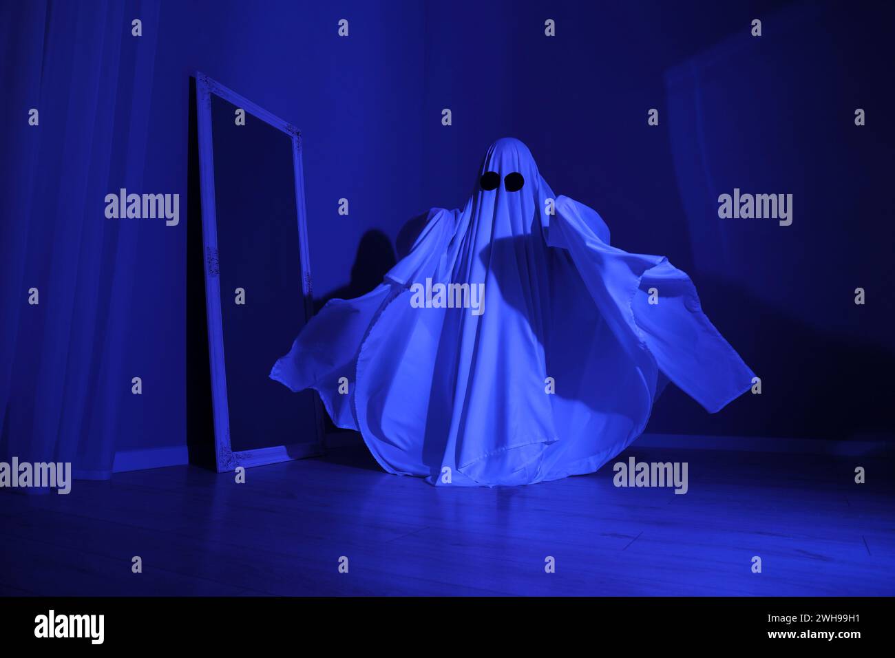 Creepy ghost. Woman covered with sheet in blue light Stock Photo - Alamy