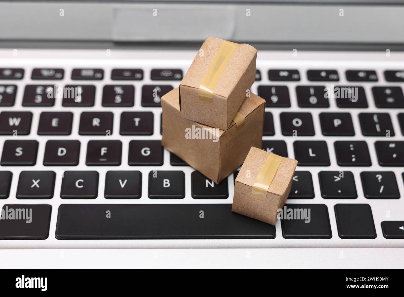 Internet shopping. Small cardboard boxes on laptop, closeup Stock Photo ...