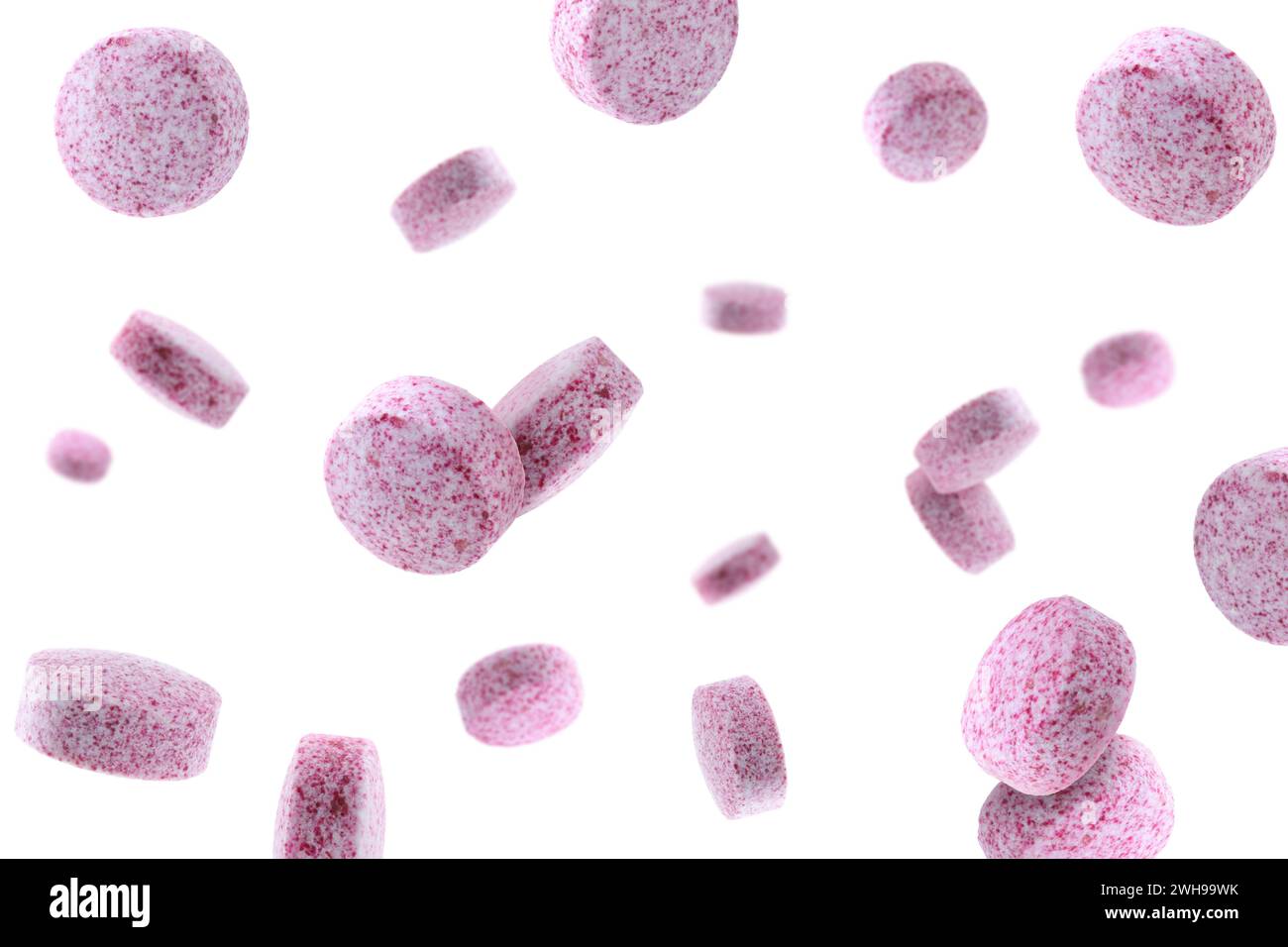 Vitamin. Pink tablets falling on white background Stock Photo - Alamy