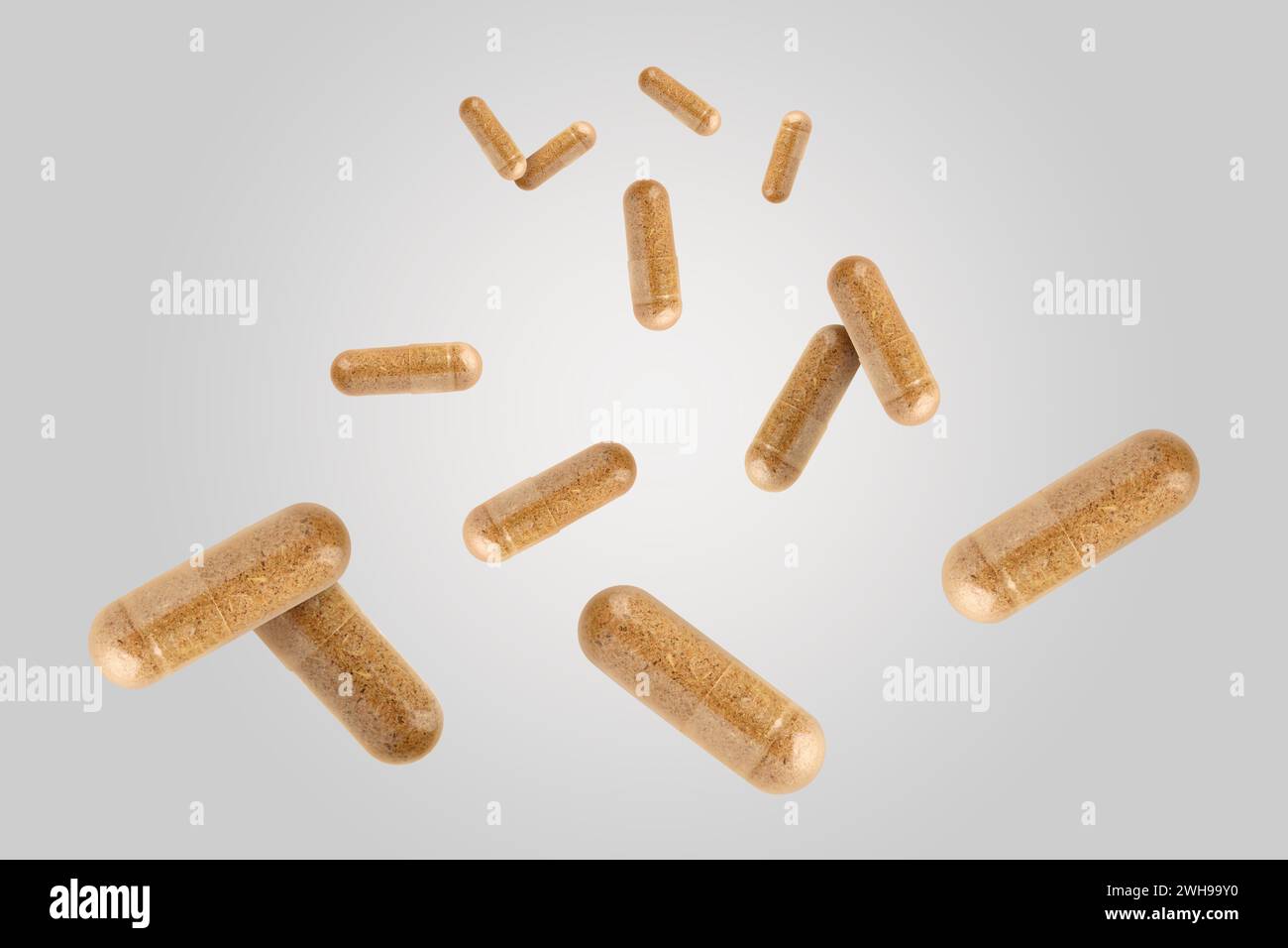 Vitamin. Capsules falling on light grey background Stock Photo - Alamy