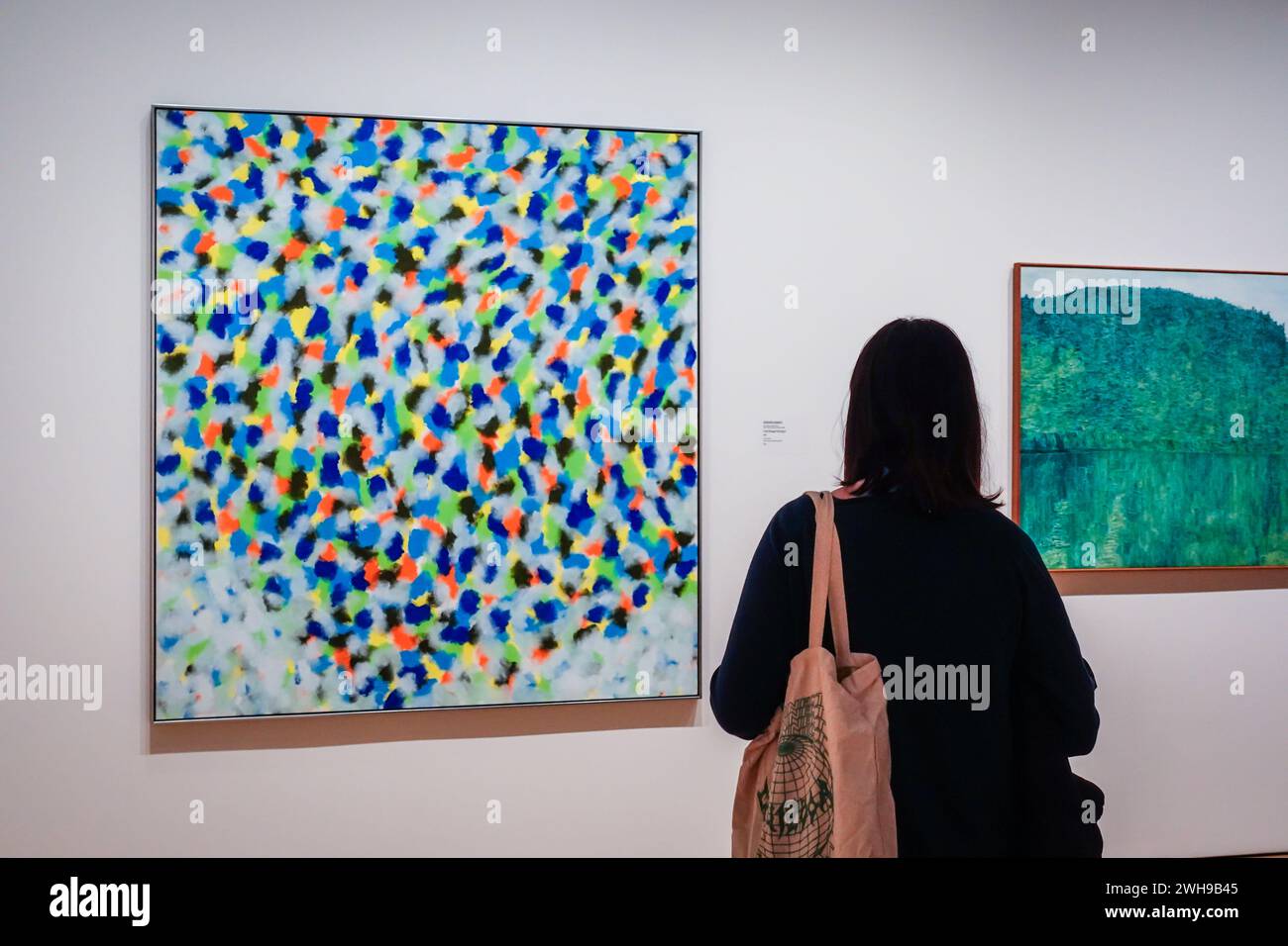 Anonymous female contemplating an abstract painting inside an art ...