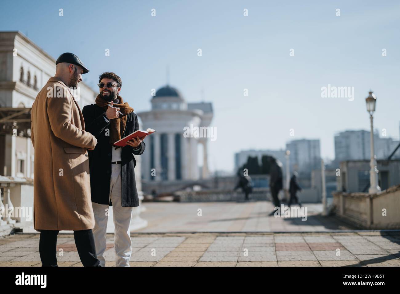 Two stylish men engaging in a friendly conversation outdoors in the ...