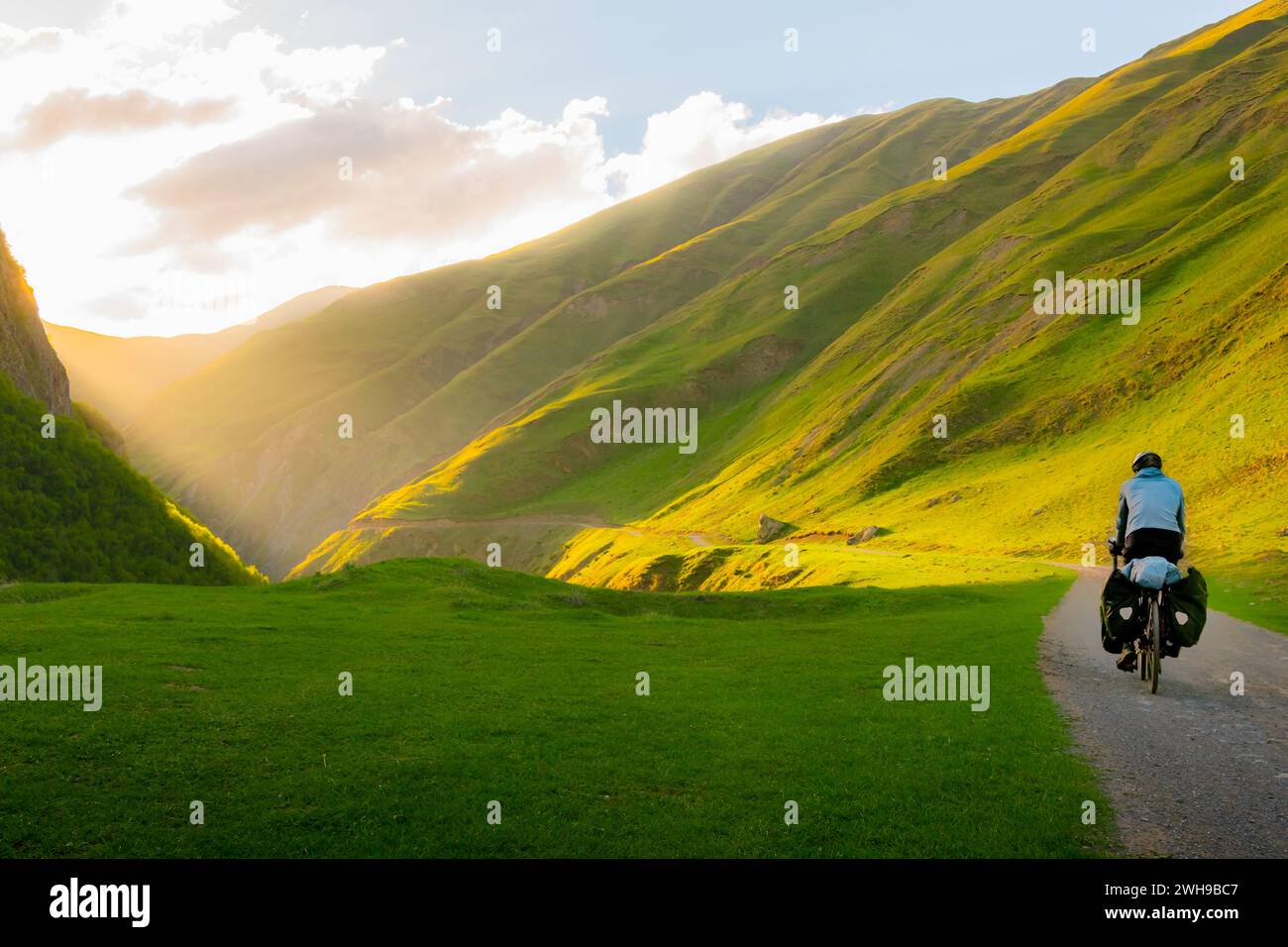 Cyclist back view on the road in scenic caucasus nature with scenic ...