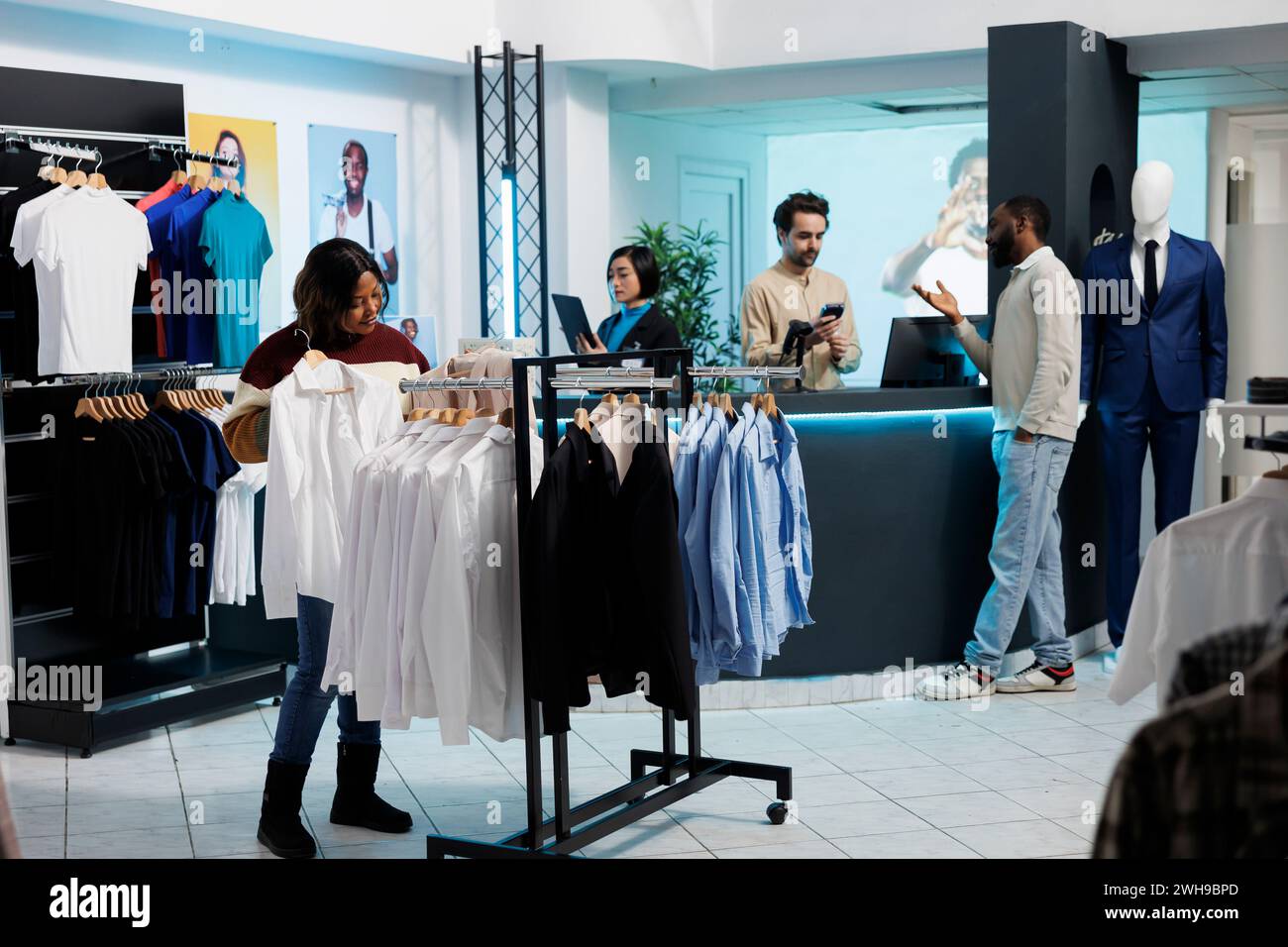 African american woman browsing rack with white shirts and selecting ...