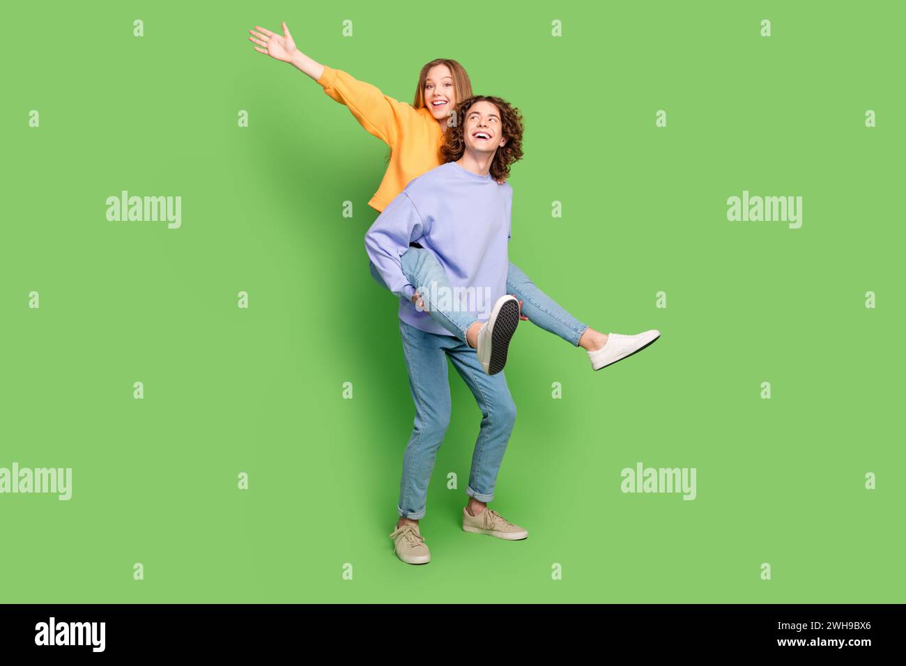 Full size photo of excited cheerful people piggyback raise arm rejoice ...