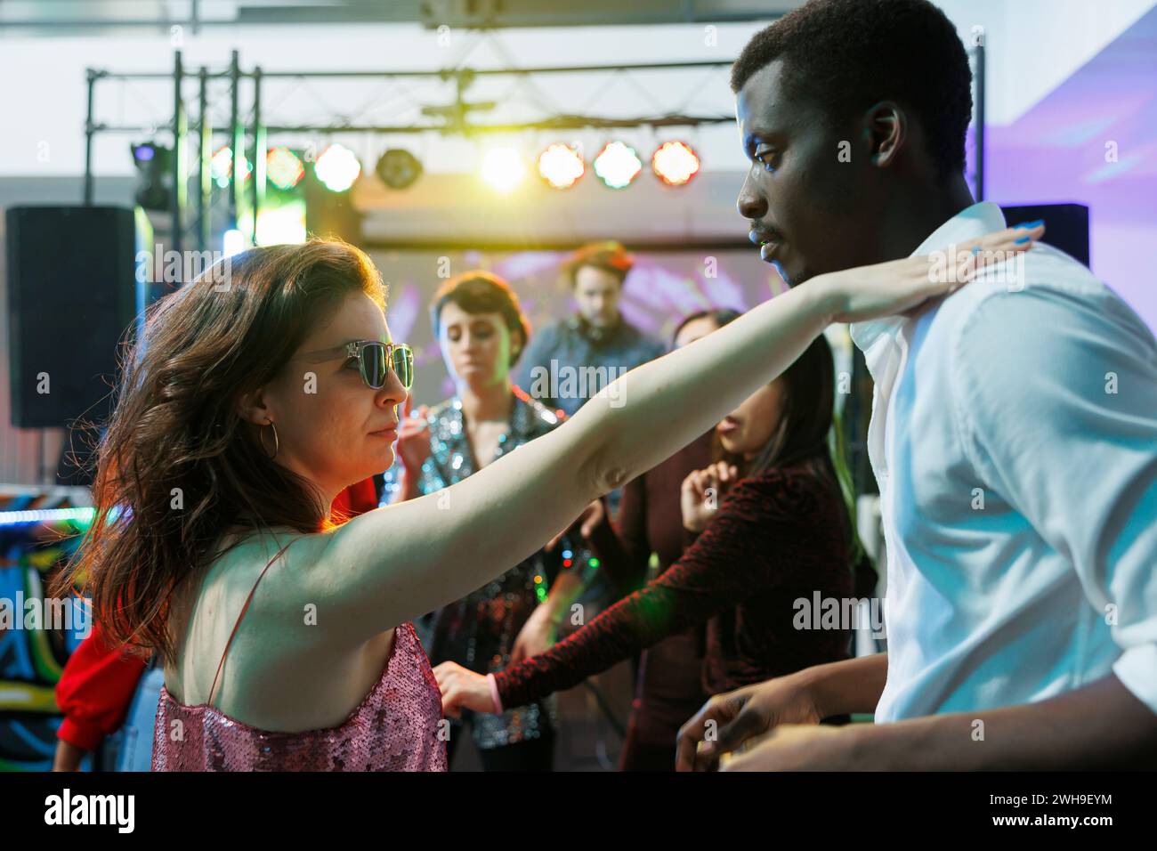 Young couple in love dancing while partying and relaxing in nightclub. Caucasian girlfriend and ...